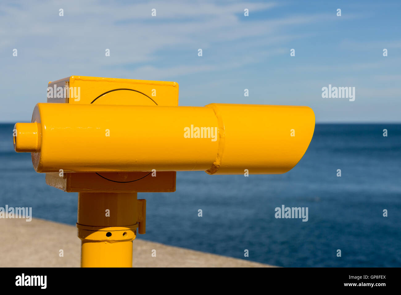 Bright yellow telescope used to view the ocean Stock Photo - Alamy