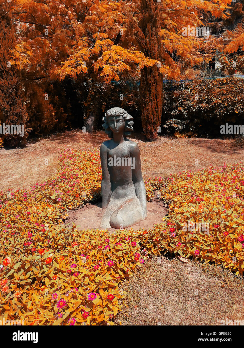 Girl statue standing in the middle of a beautiful ornamental garden ...