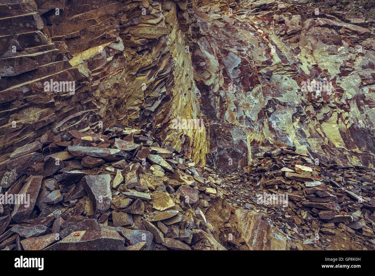 Arid strata volcanic rock cliff and stone debris in a old abandoned ...