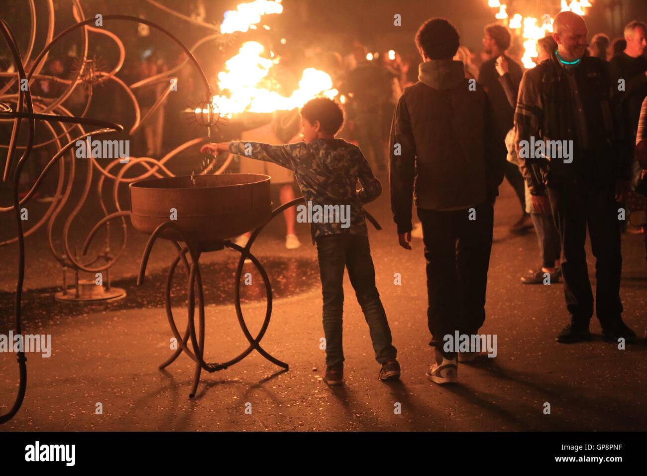 With burning metal structures, cascading candles and flickering ...