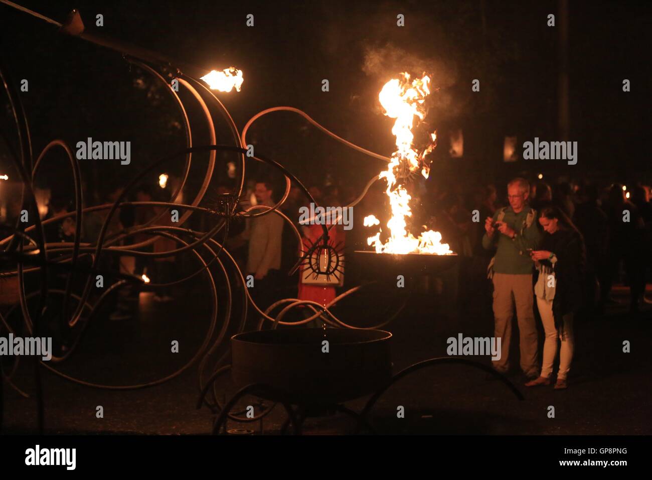 With burning metal structures, cascading candles and flickering ...