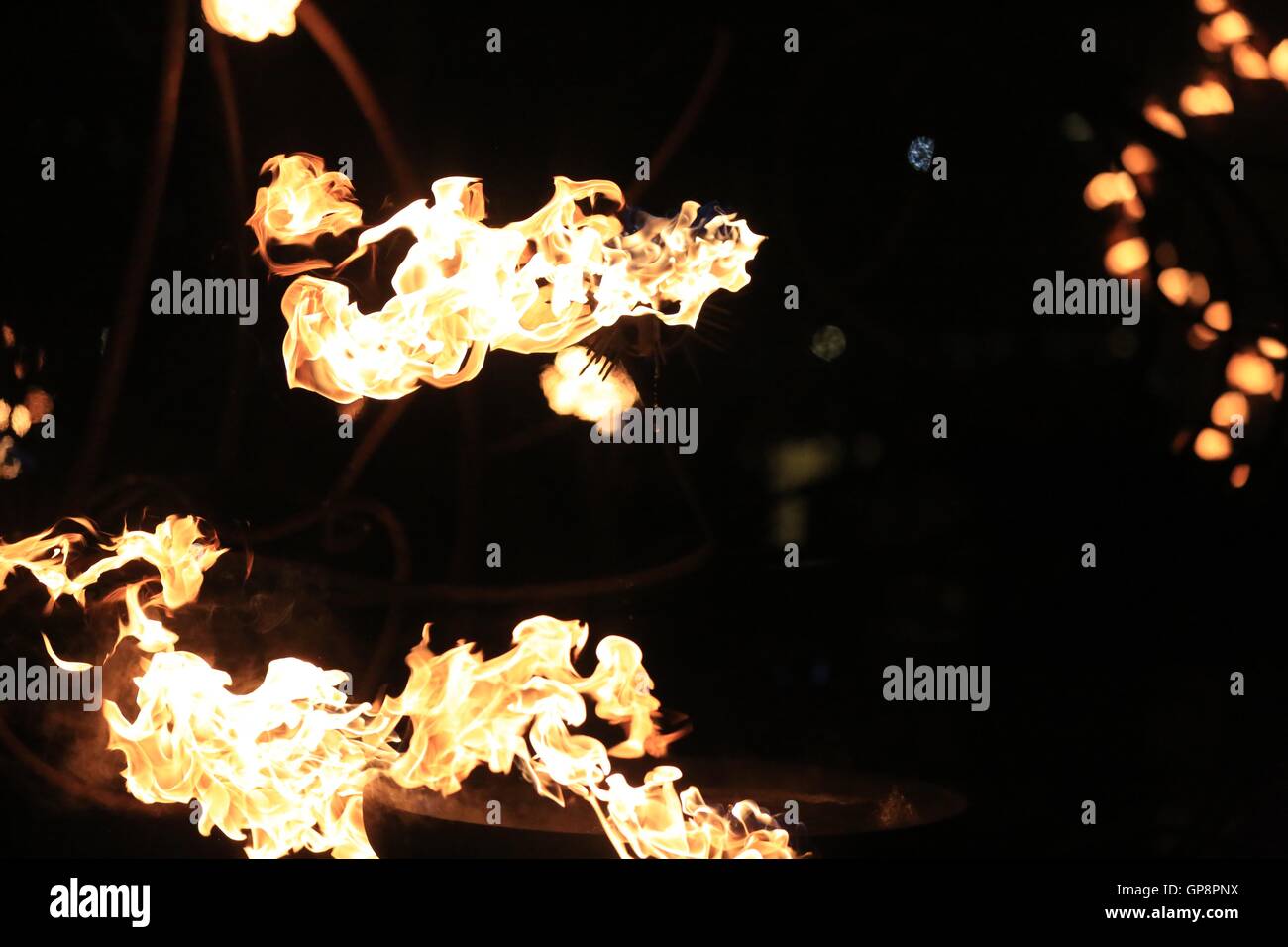 With burning metal structures, cascading candles and flickering ...