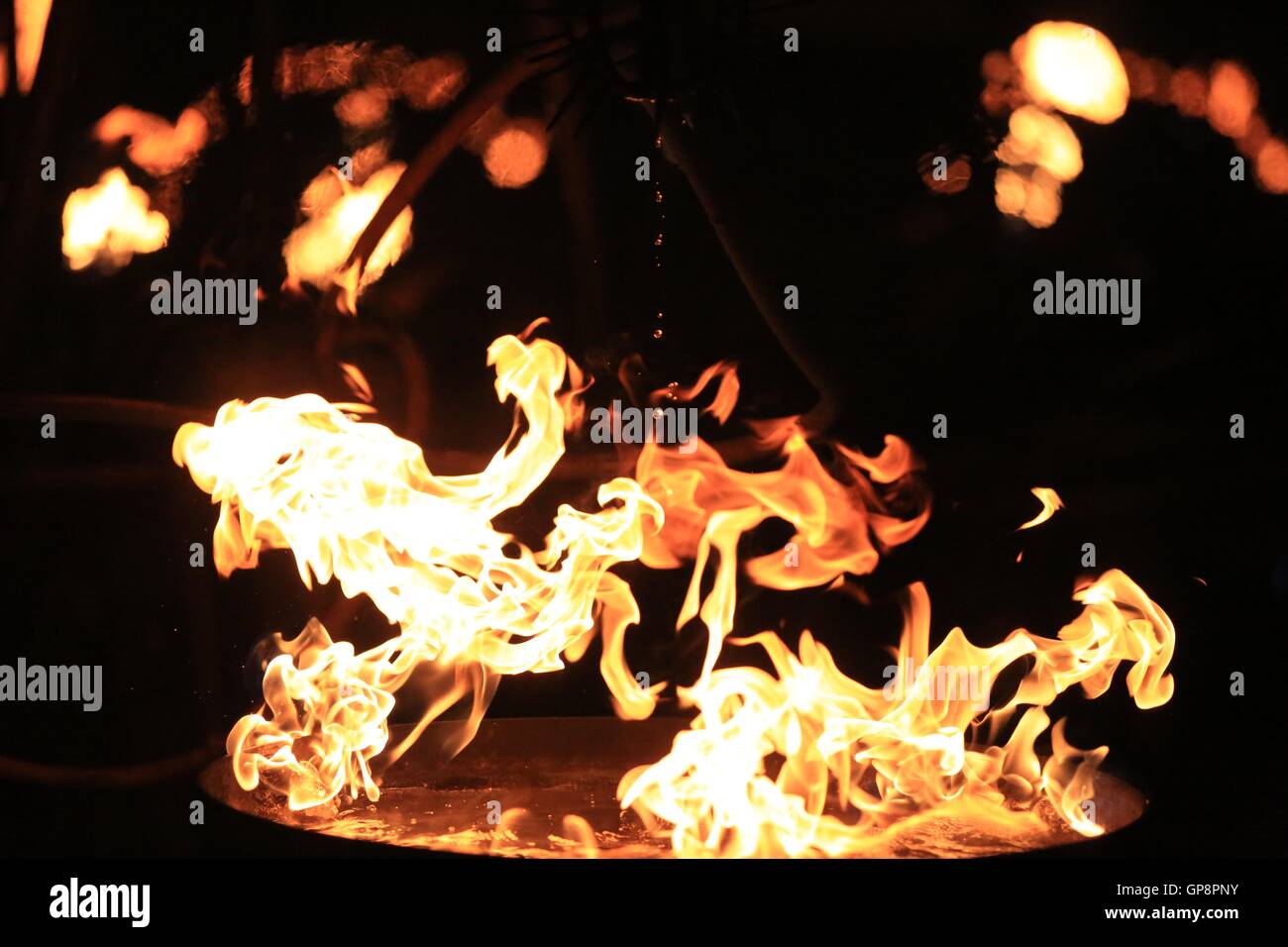 With burning metal structures, cascading candles and flickering ...