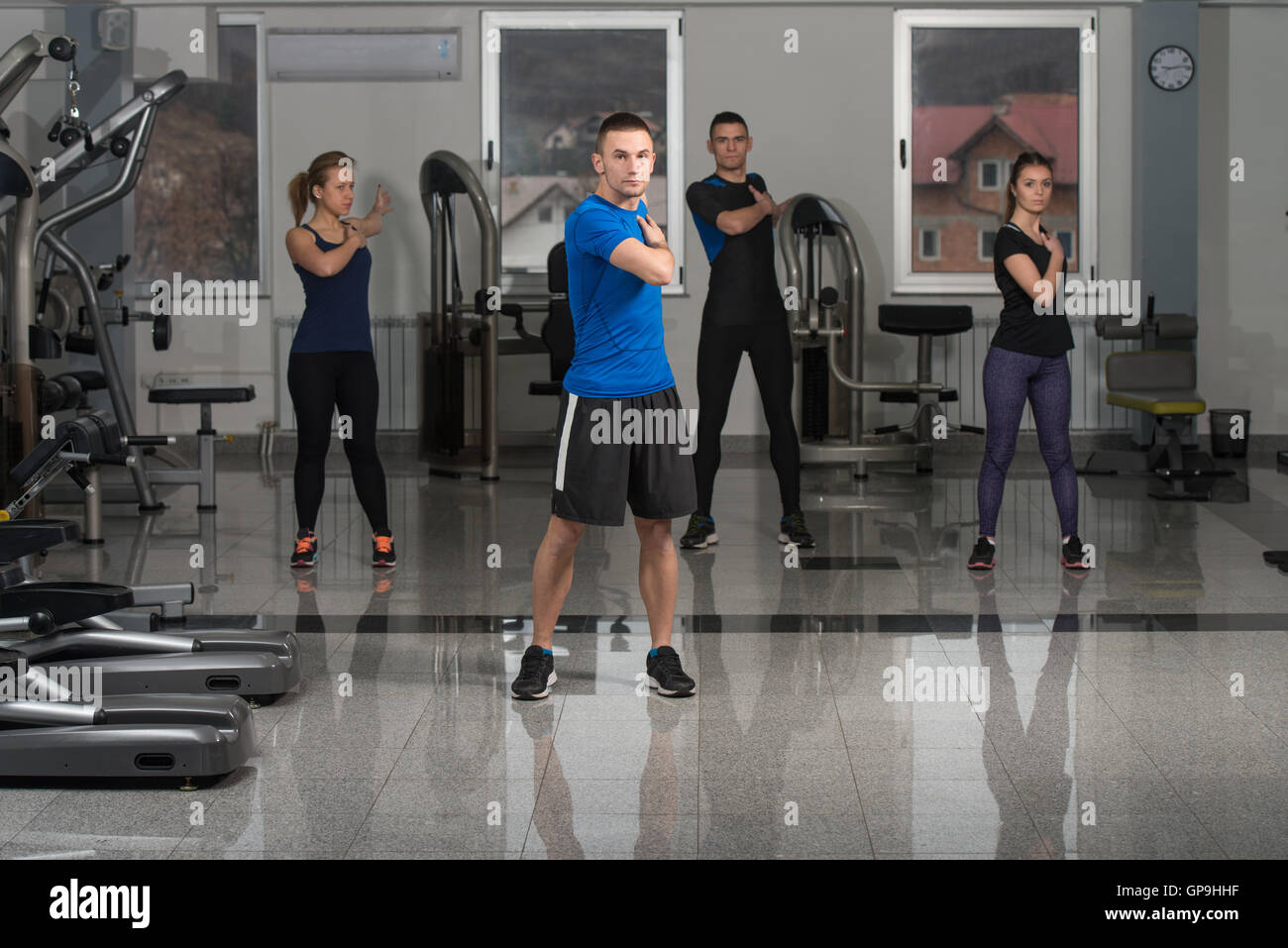 Instructor With Fitness Class Performing Step Aerobics Exercise In Gym ...