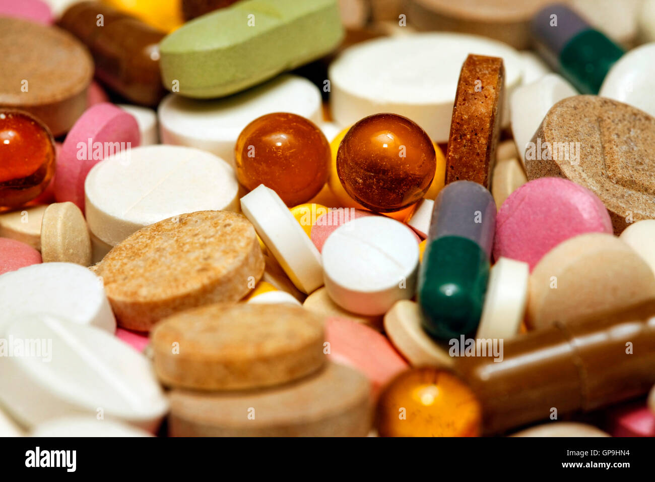 Assorted colorful pills and capsules on white background close up ...
