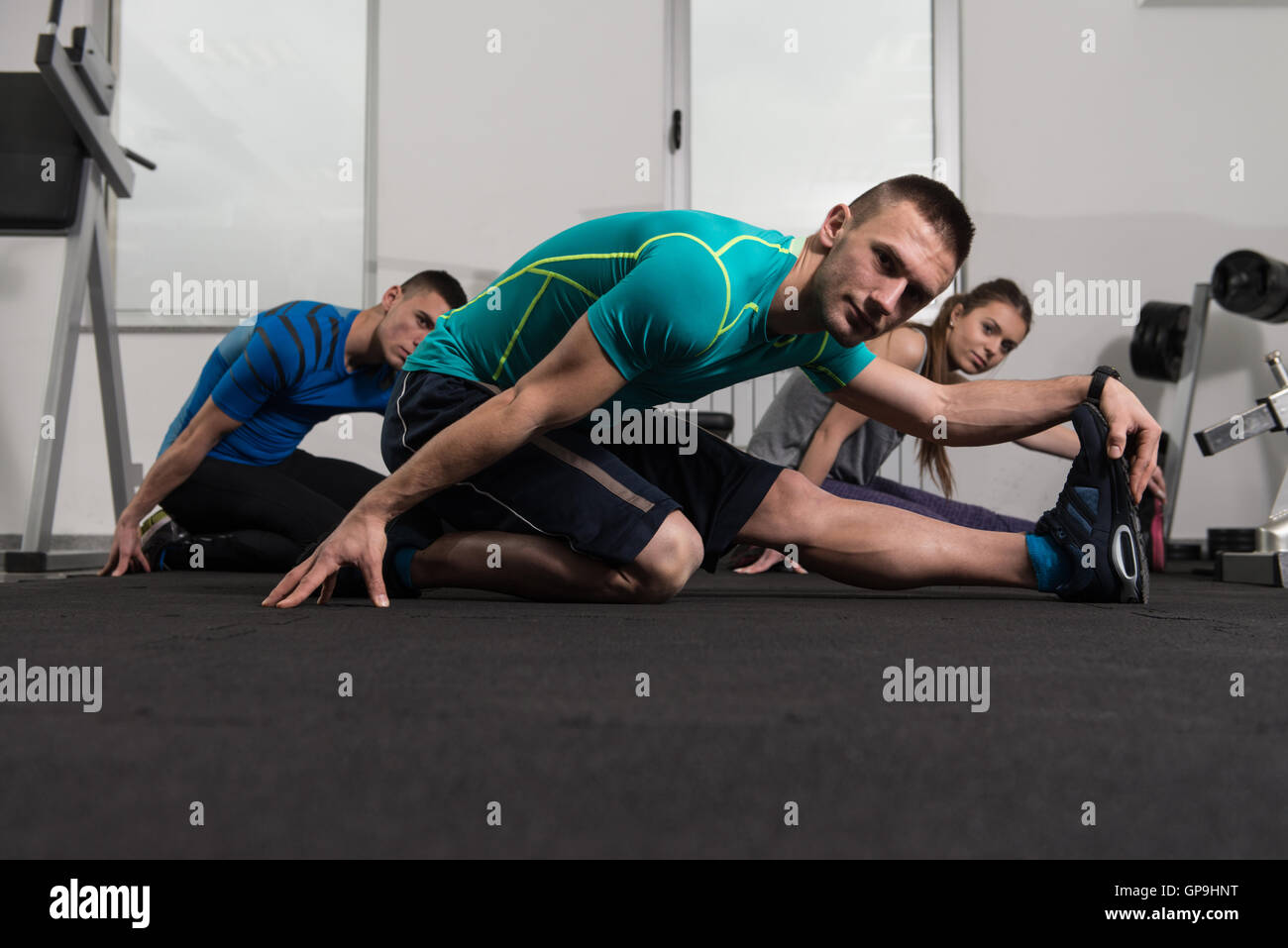 Group Of Athletes Stretching Before Starting A Workout Session Stock ...