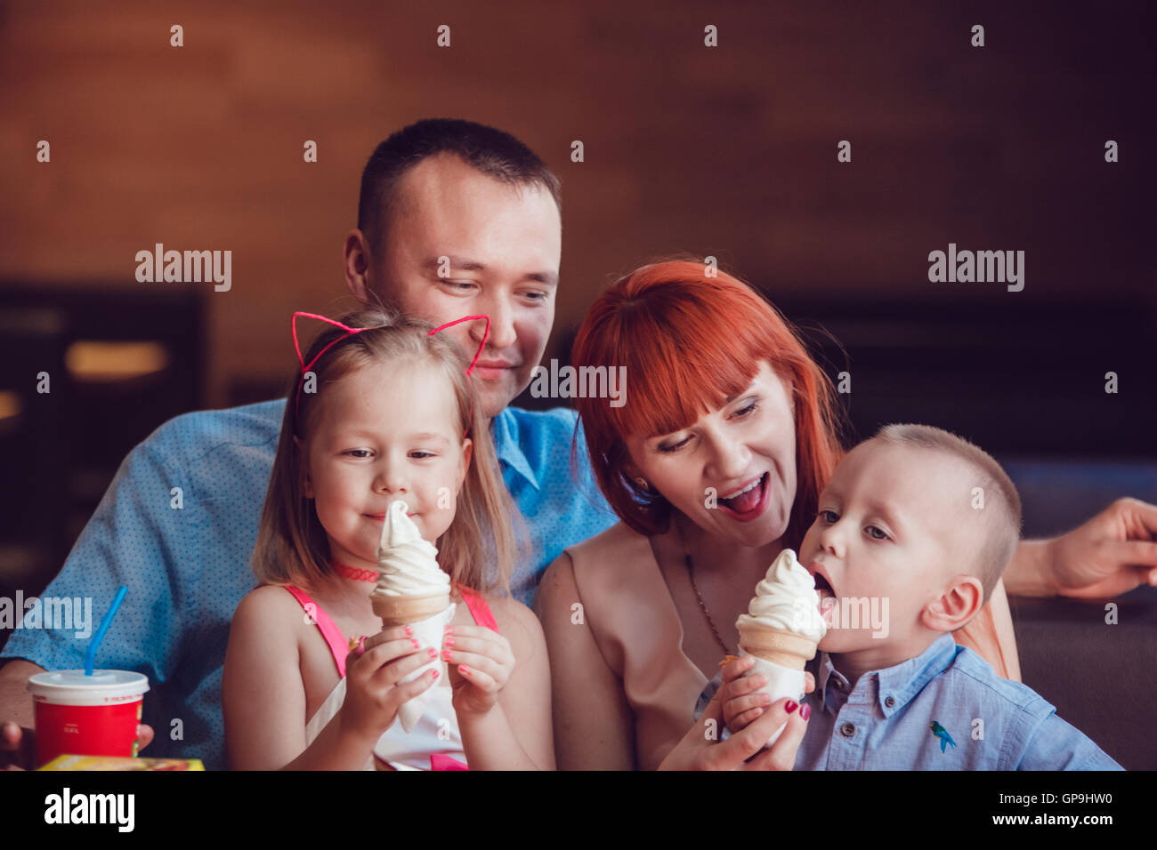 Happy family eating ice cream in restaurant Stock Photo - Alamy