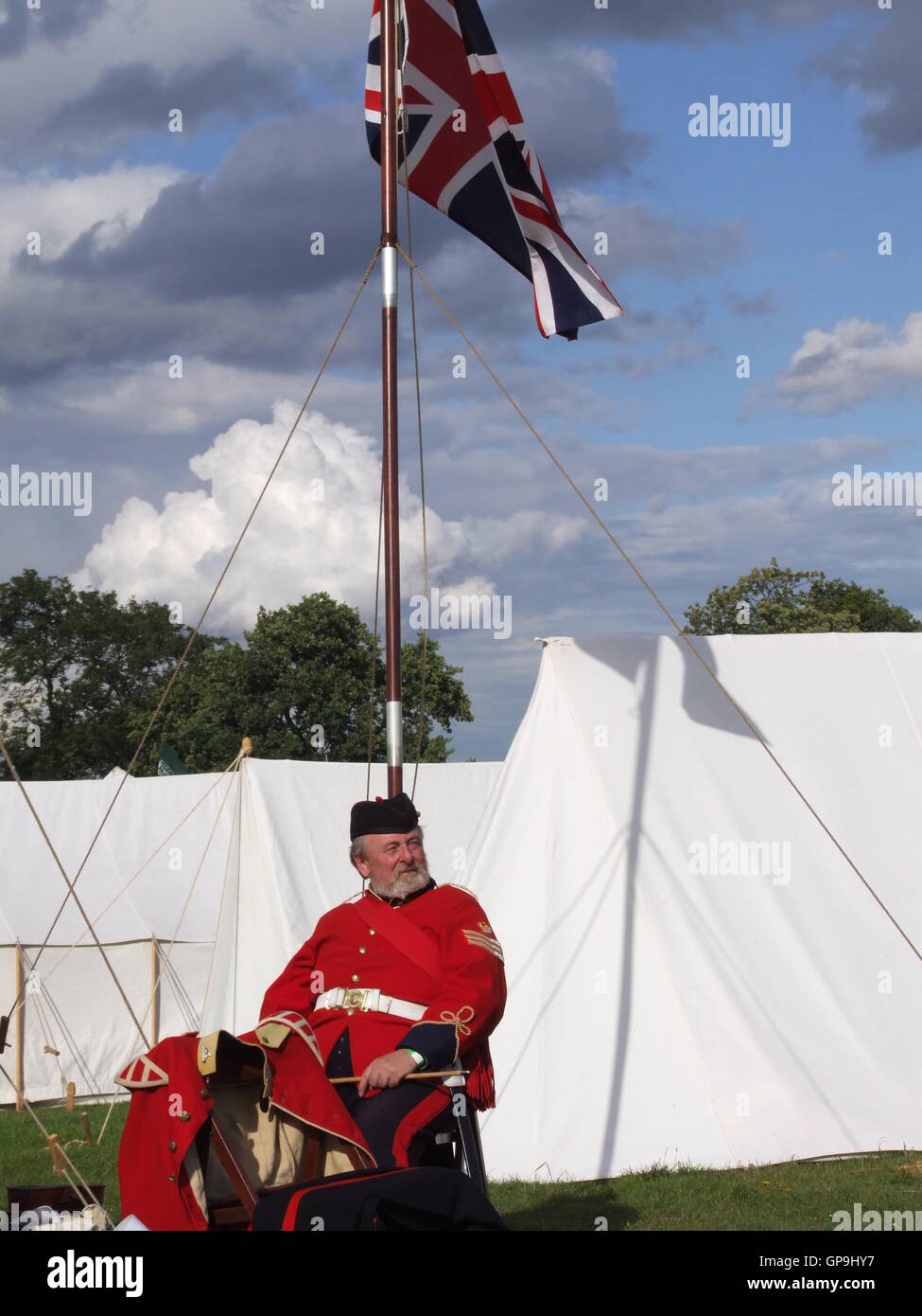 Soldier relaxing by tent under Union Jack flag Stock Photo - Alamy