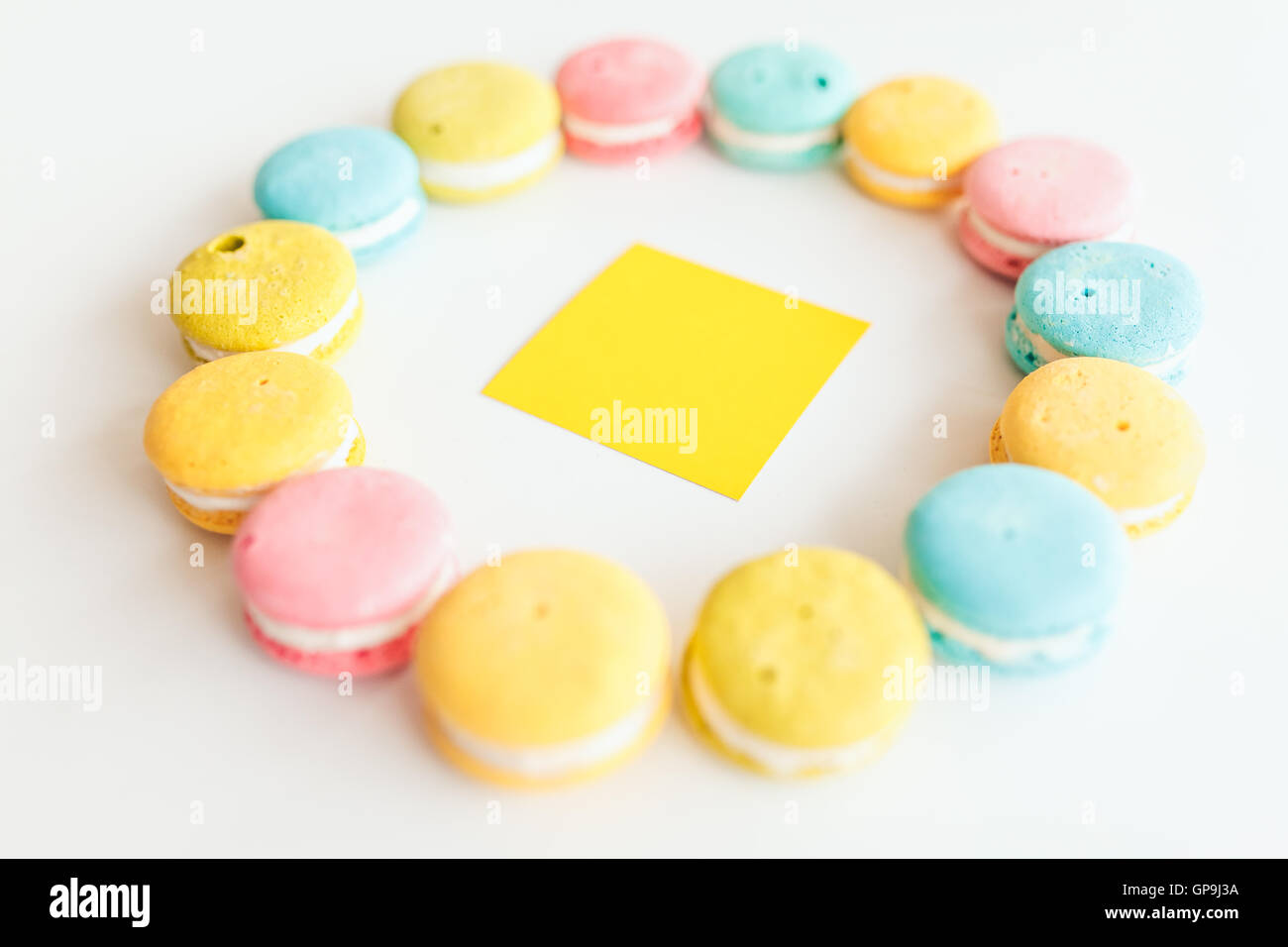 French macaroons laid out in a circle shape on white background with a ...