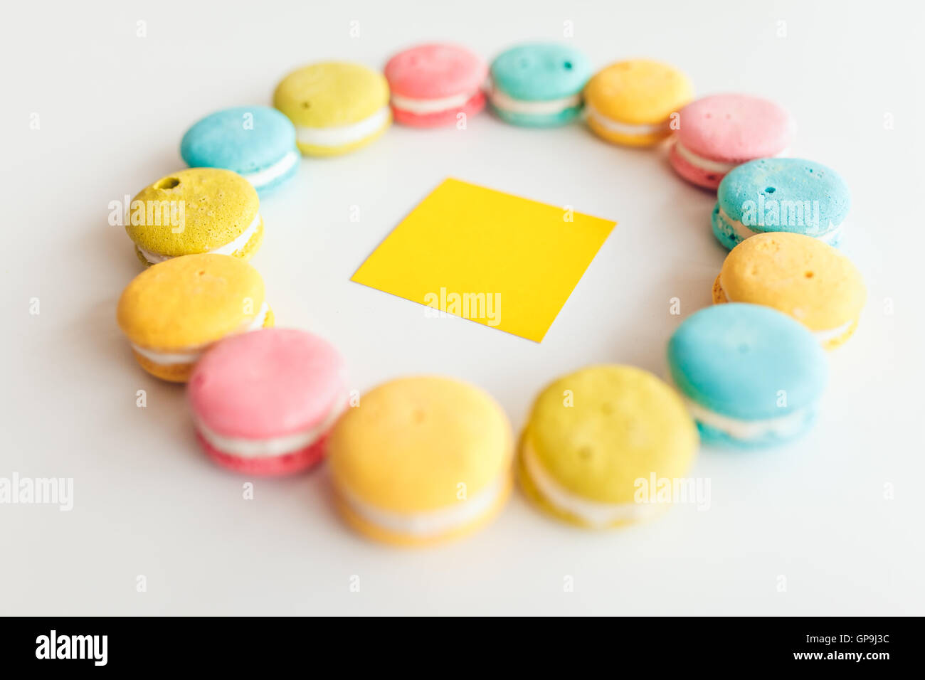 French macaroons laid out in a circle shape on white background with a ...