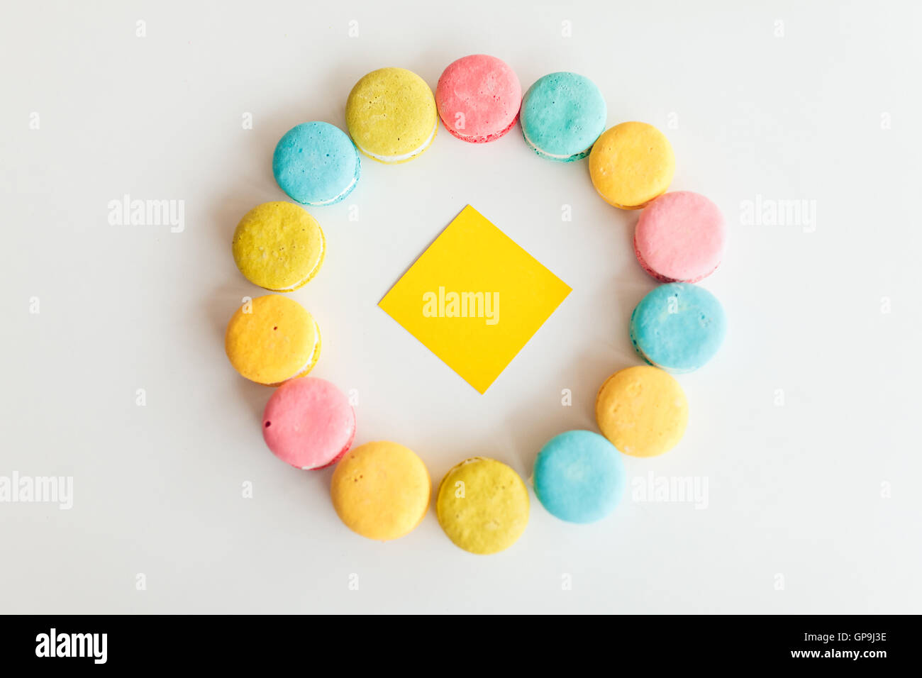 French macaroons laid out in a circle shape on white background with a ...
