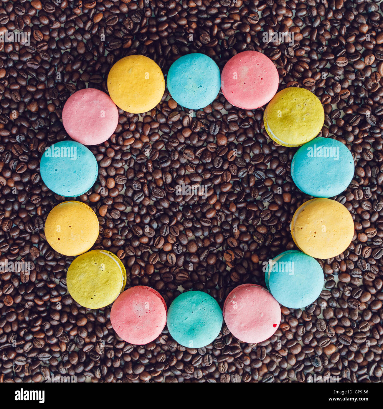 French macaroons laid out in a circle shape on coffee beans background ...