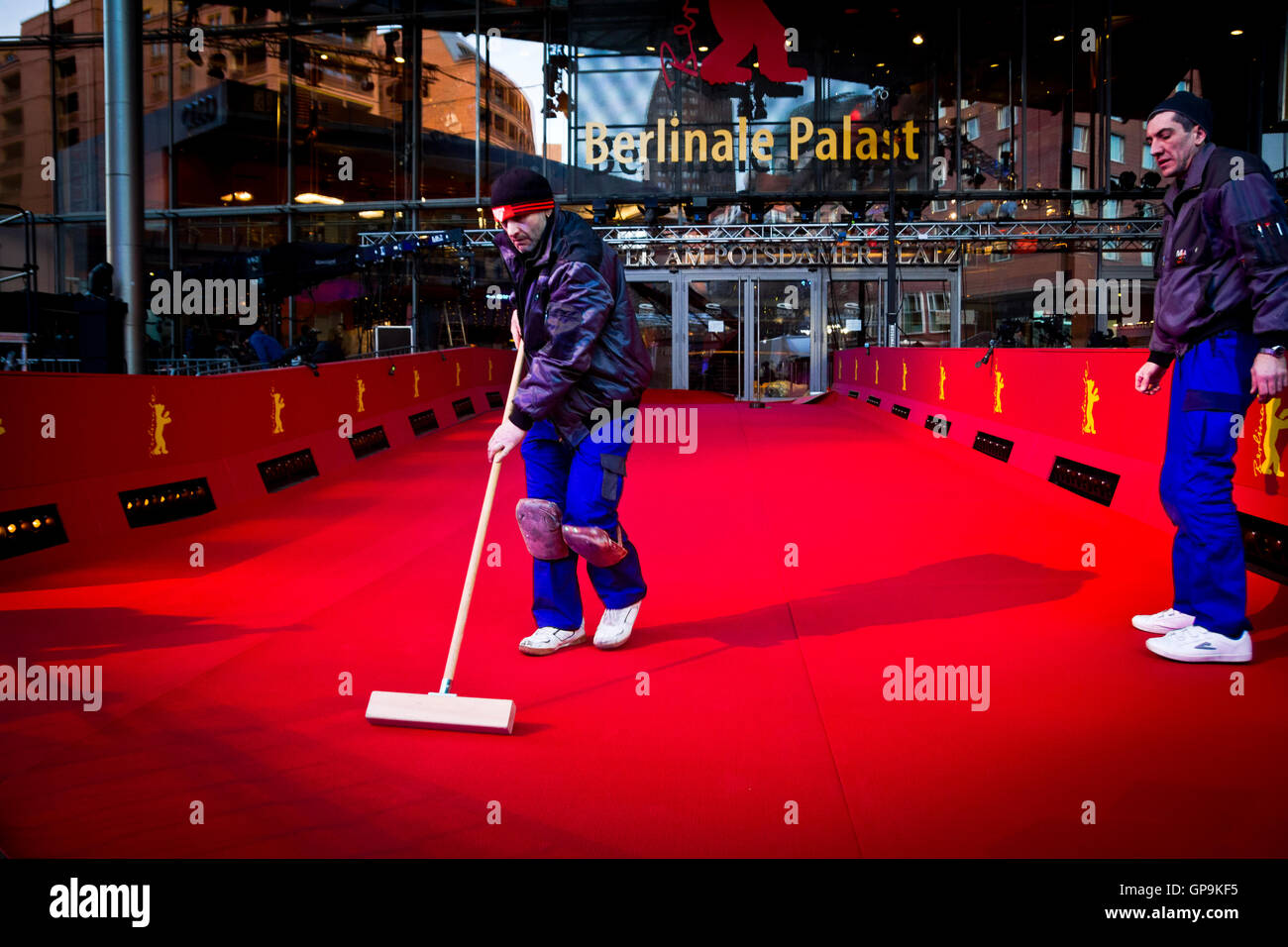 A worker sweeping the red carpet outside the Potsdamer Platz Theatre in ...