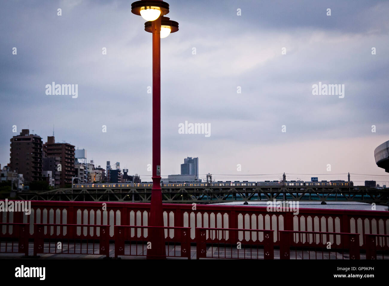 A train passes over a distant bridge in Tokyo, Japan Stock Photo - Alamy