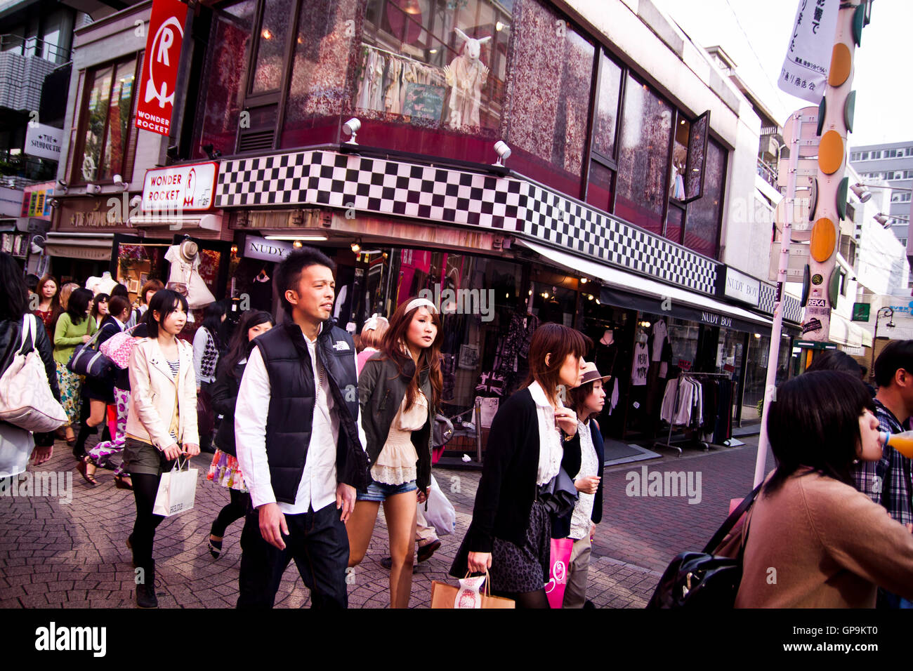 People walk through the main shopping street of Harajuku in Tokyo ...