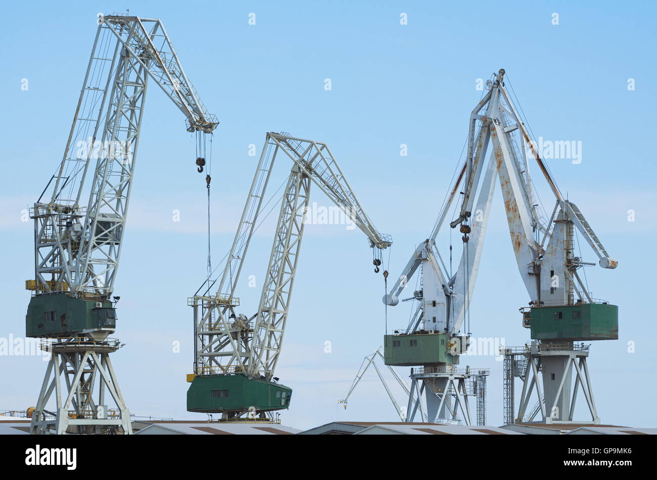 Four Giant Shipyard Cranes Against Blue Sky Stock Photo - Alamy