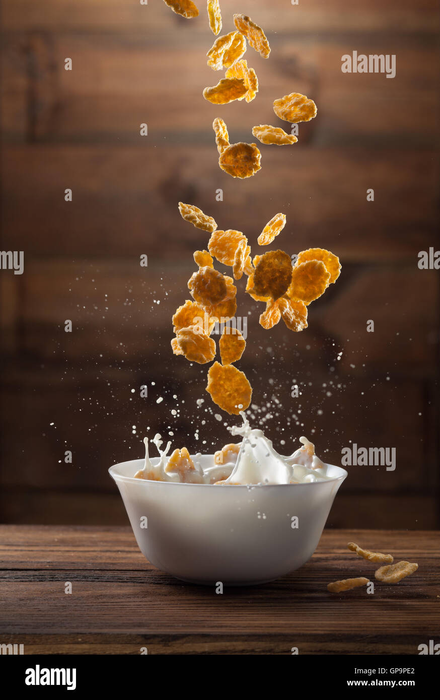 Falling corn flakes with milk splash on wood Stock Photo - Alamy