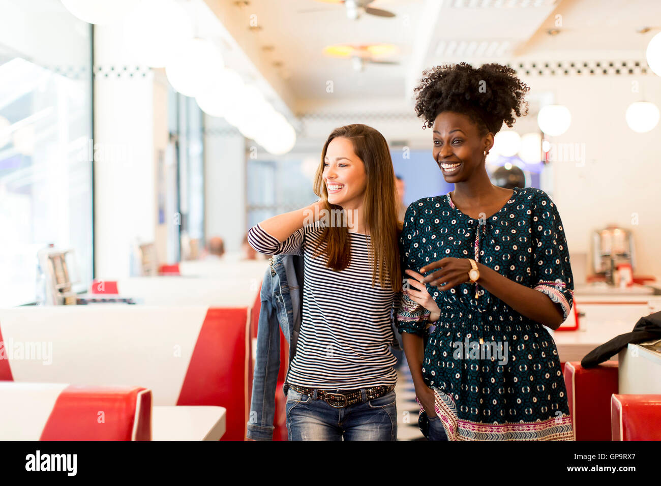 Two young women socializing in the diner Stock Photo - Alamy