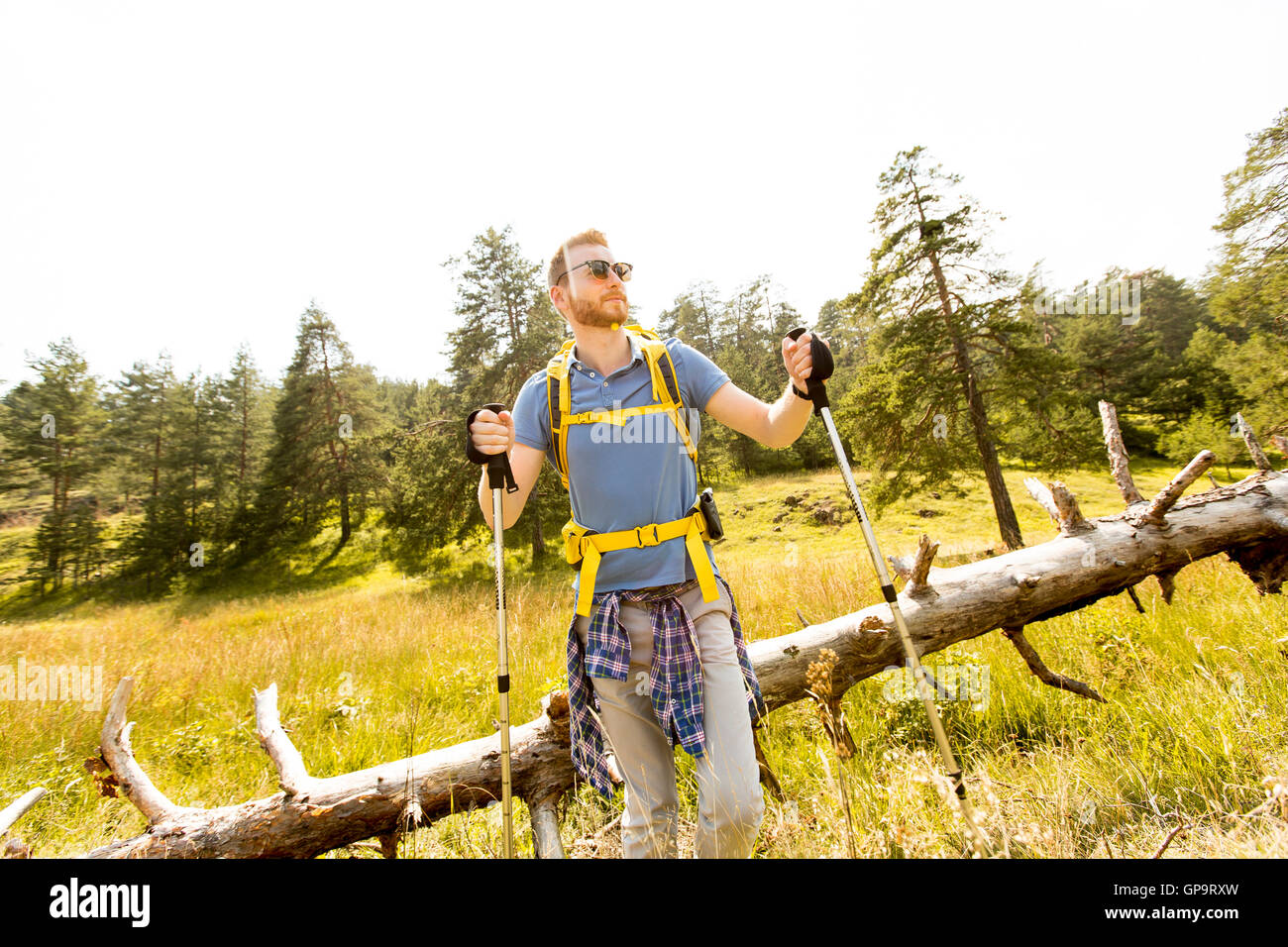 Caucasian male model with backpack hiking on sunny day Stock Photo - Alamy