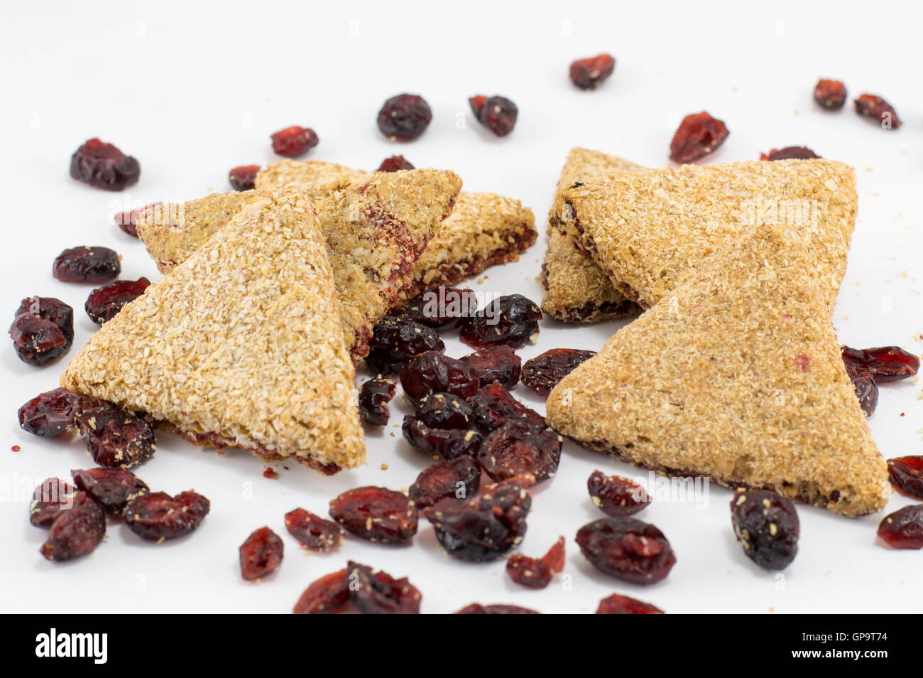 Integral triangle cookies with red raisins on white table Stock Photo ...