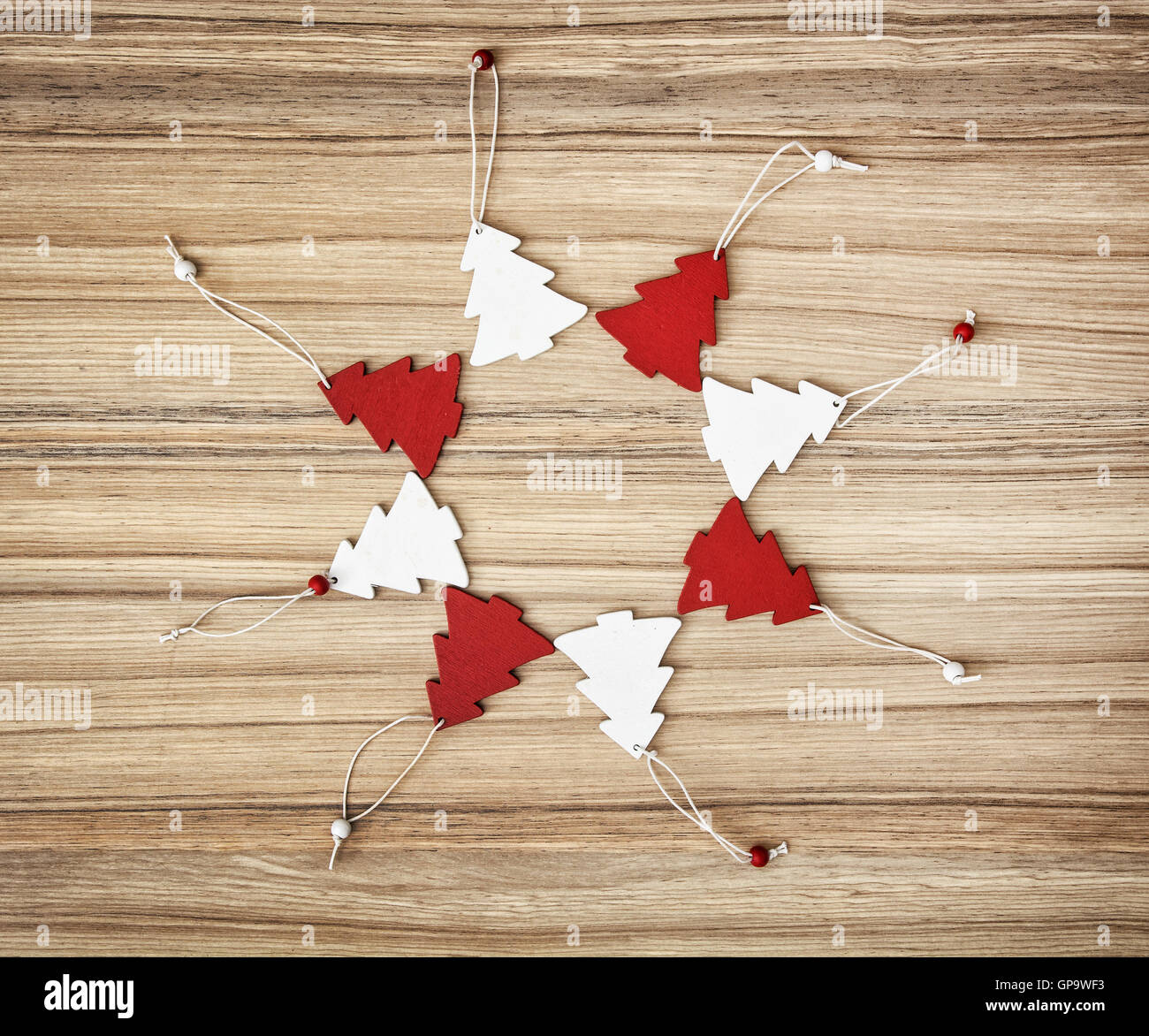Red and white decorative christmas trees in circle shape on the wooden ...
