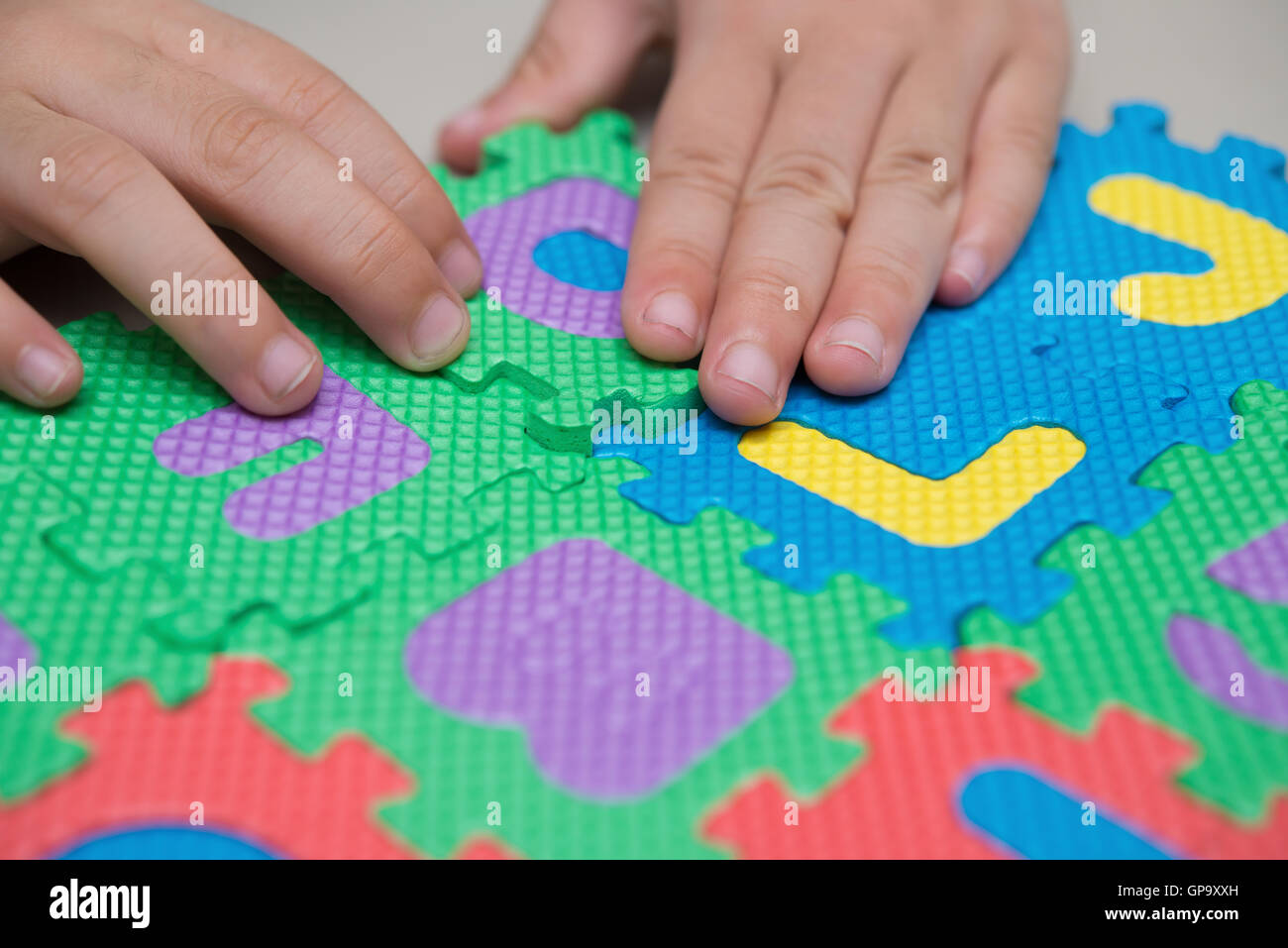 kid playing alphabet jigsaw puzzles Stock Photo - Alamy
