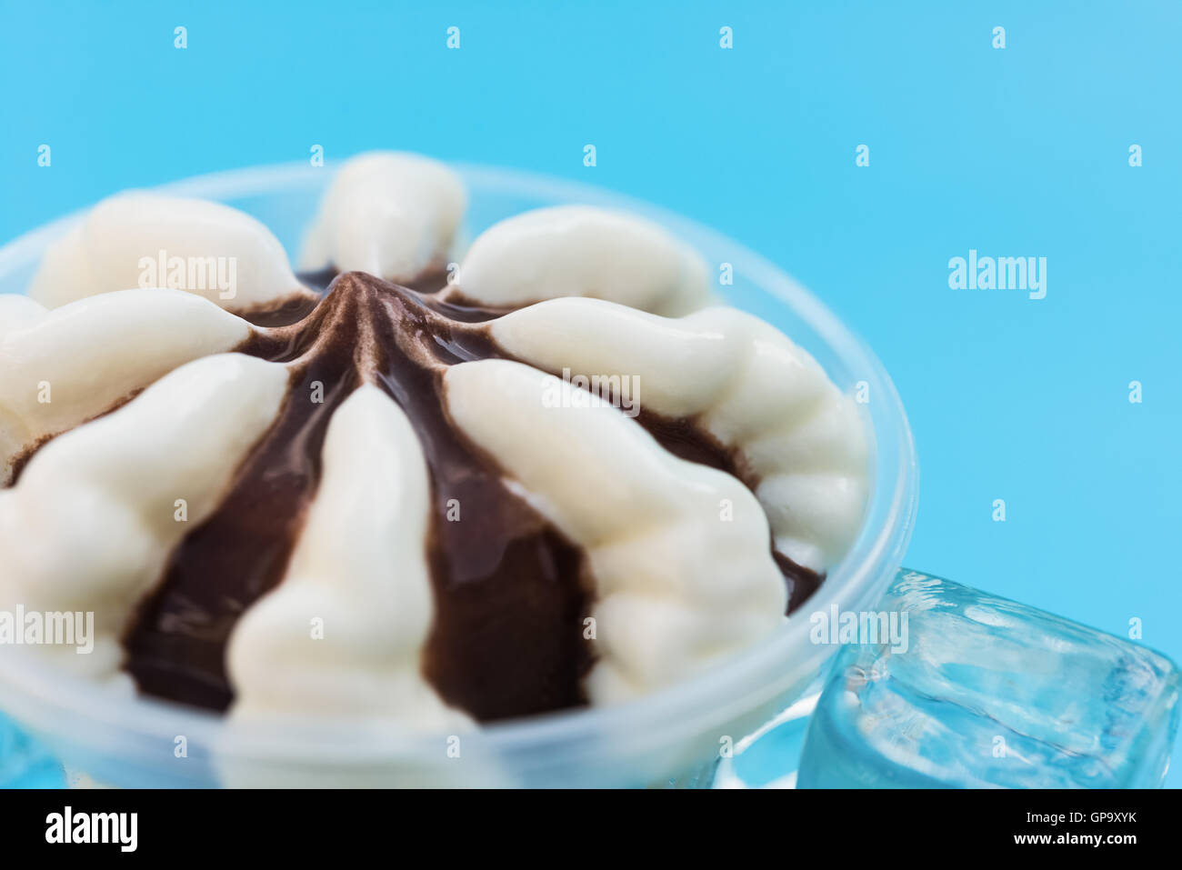side view cup of chocolate flavor ice cream and ice cube on blue ...
