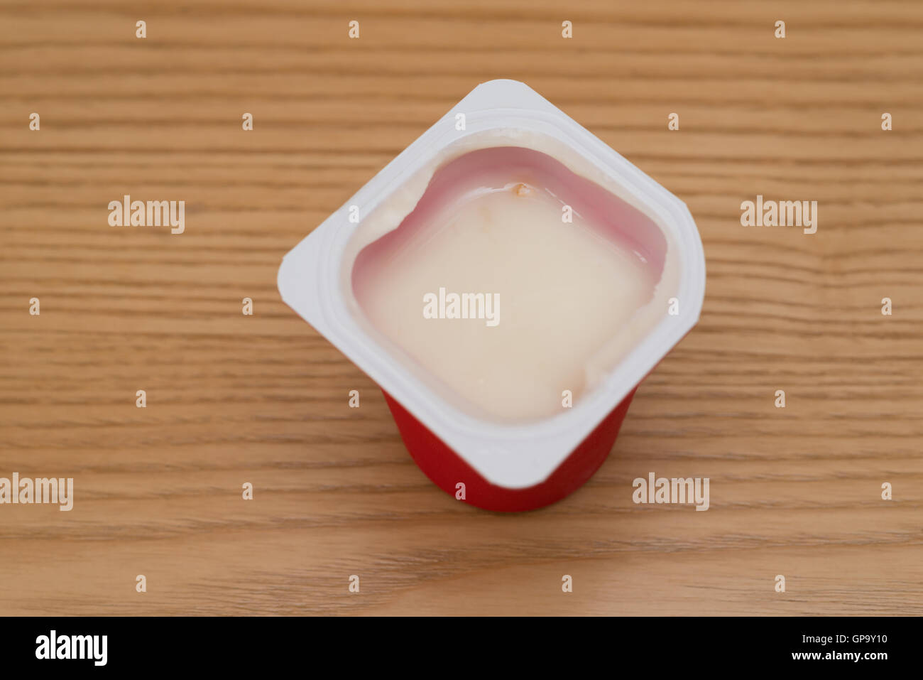 top view cup of fresh yogurt just been opened on a wood table Stock ...