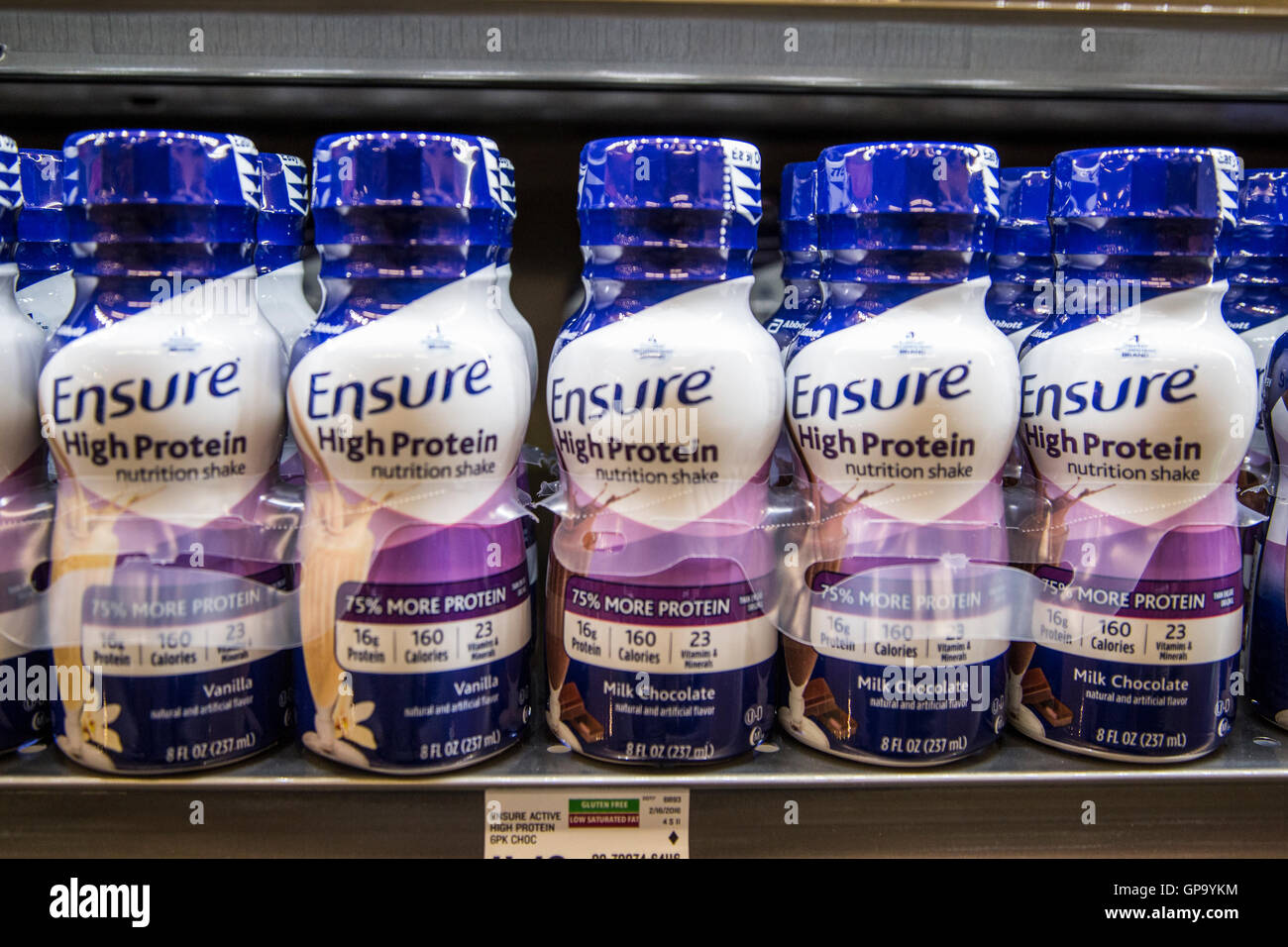 bottles of Ensure nutrition shakes in a row on a shelf at a grocery ...