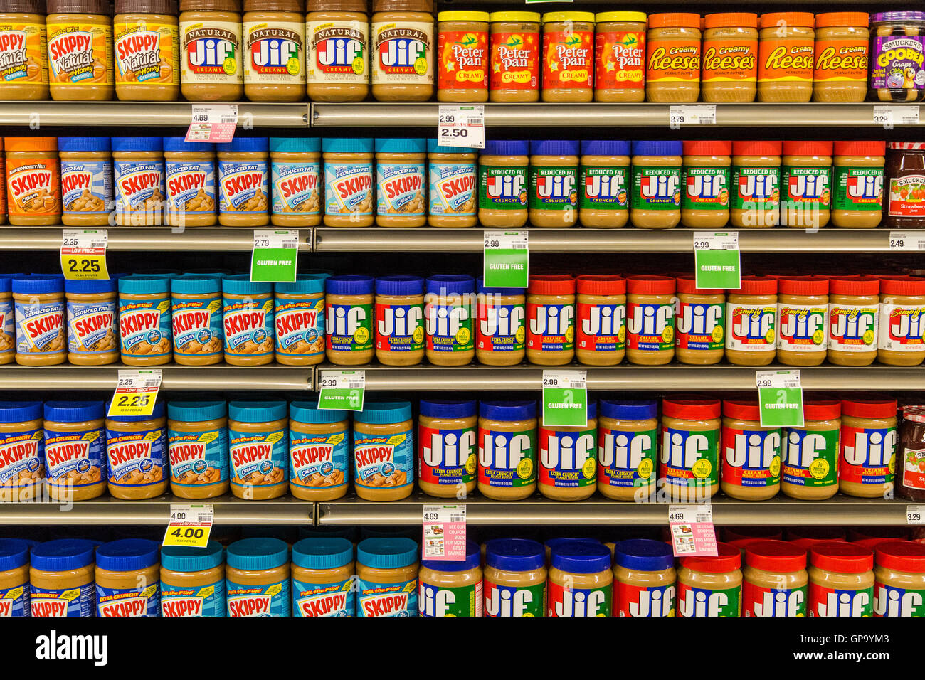 Jars of name brand peanut butter displayed on shelves at a grocery ...