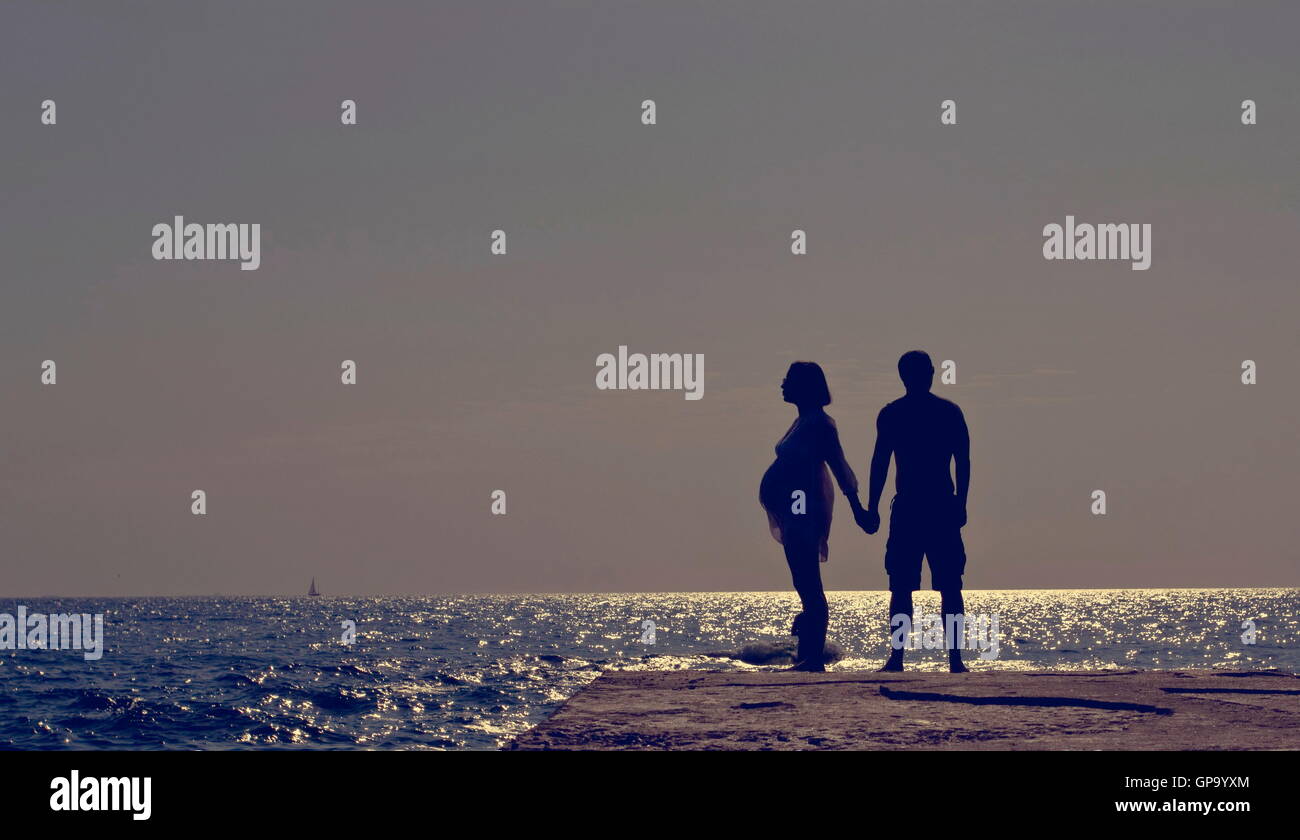 Young Family Waiting for the Miracle. Romantic Couple on a Beach at ...