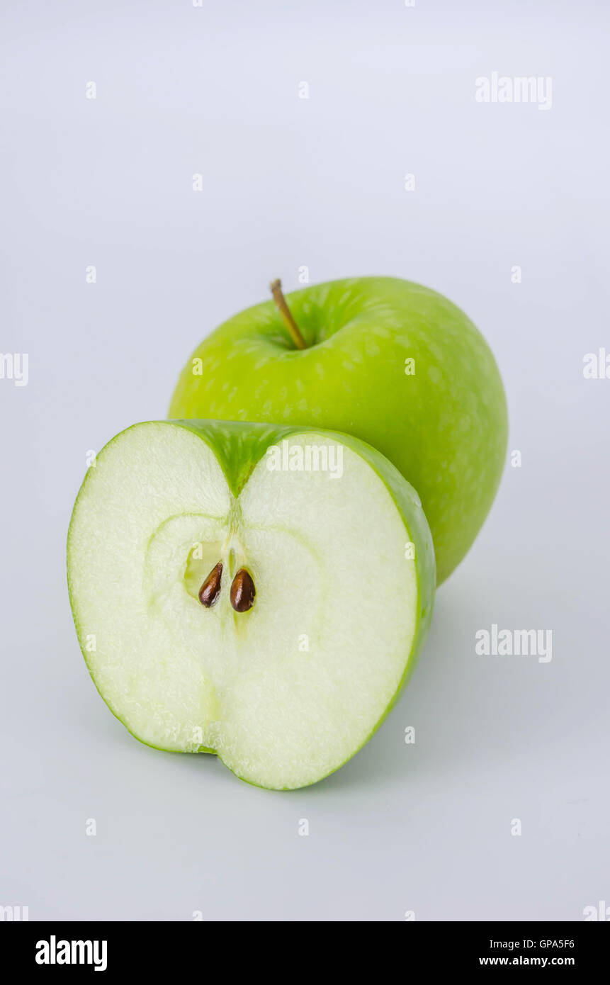 Ripe green apple and half on a white background Stock Photo - Alamy