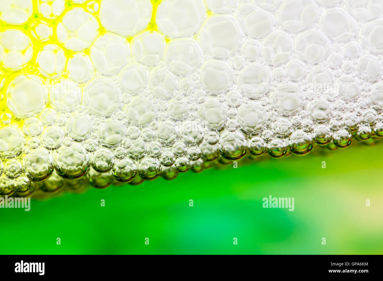 Close up of soap suds floating on water with dye flowing through. Foam ...
