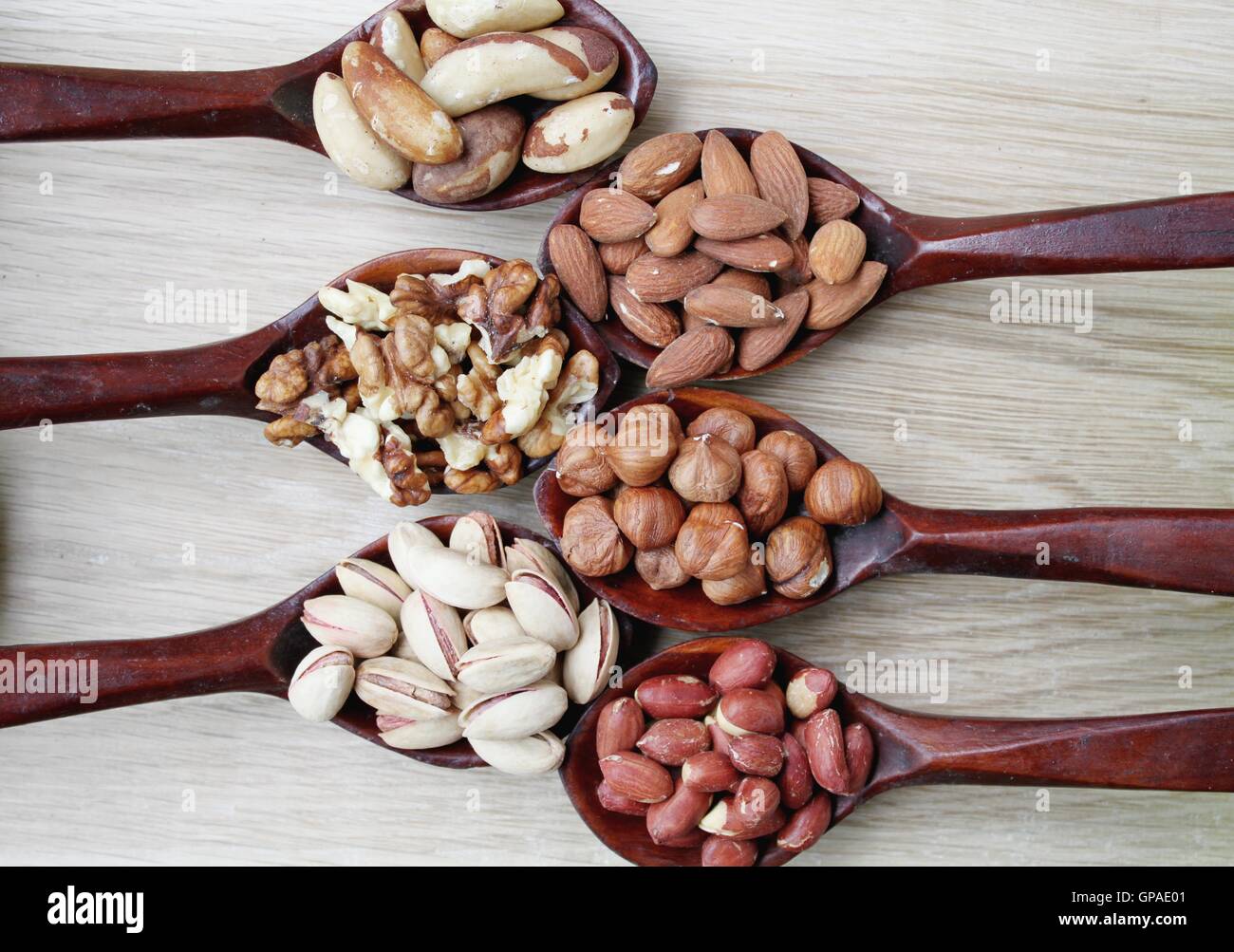 Nuts in wooden spoons Stock Photo - Alamy