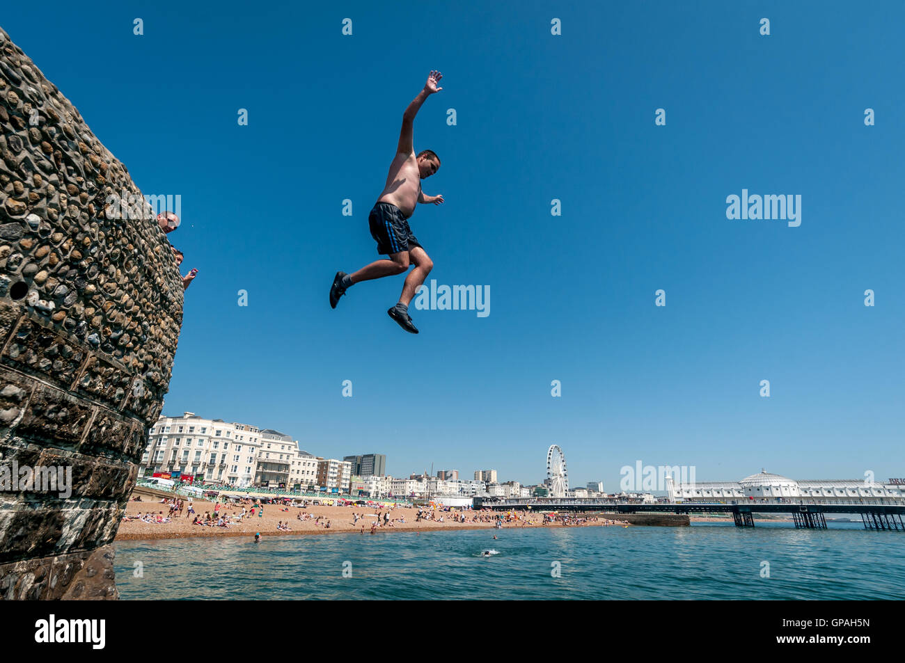 Teenagers diving and jumping into the sea from a groyne on Brighton ...