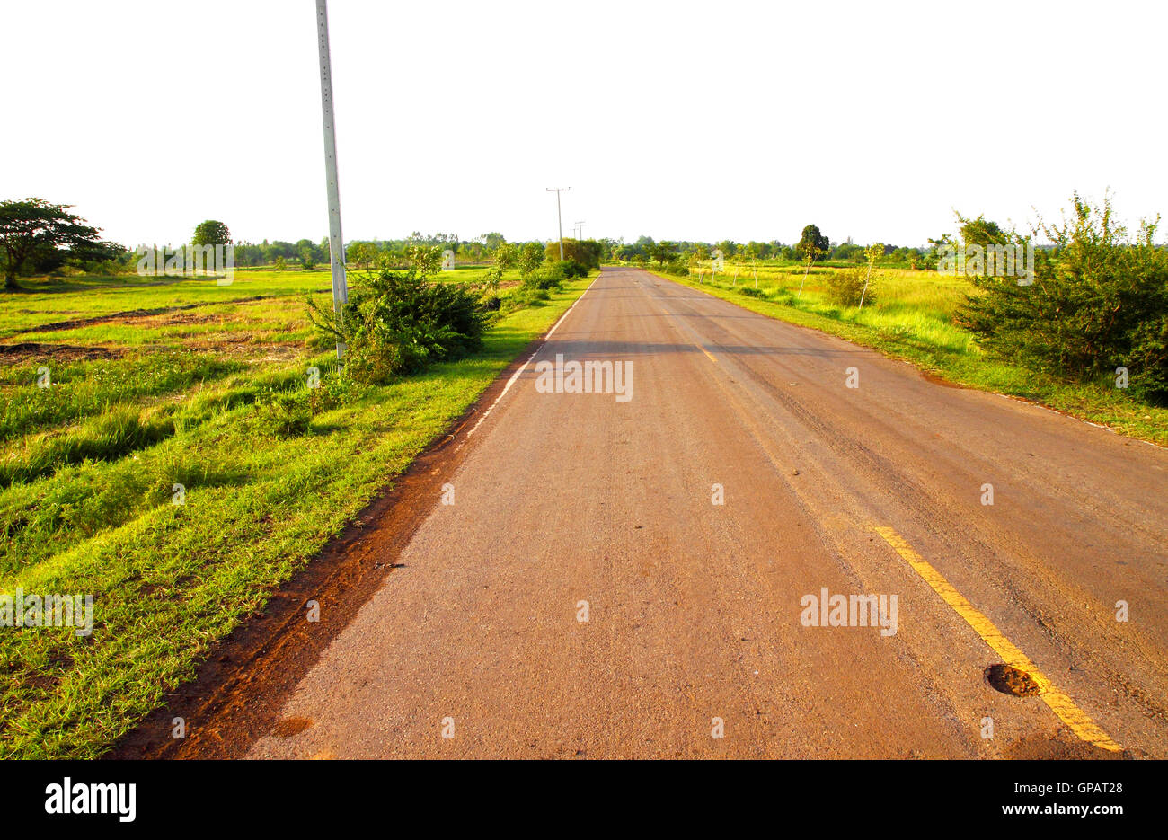A country road running through green fields Stock Photo - Alamy