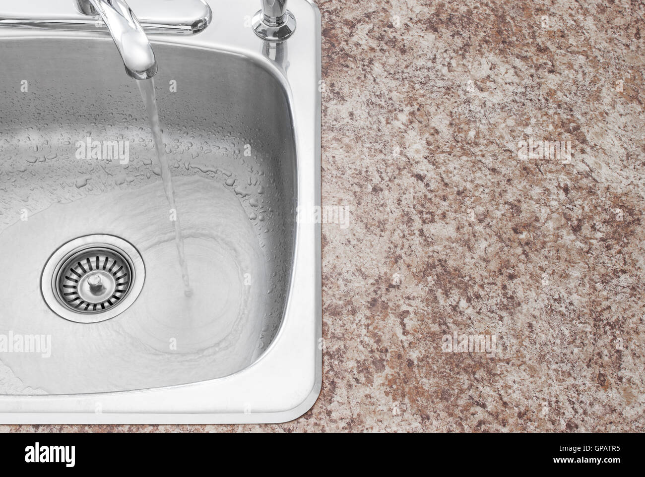 Water running from kitchen faucet and countertop detail Stock Photo - Alamy