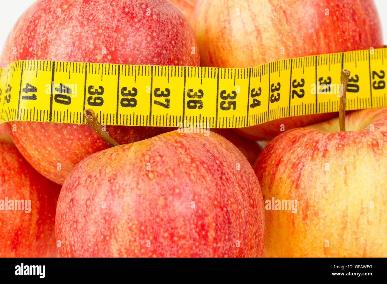 Red apples with a yellow tape-measure Stock Photo - Alamy