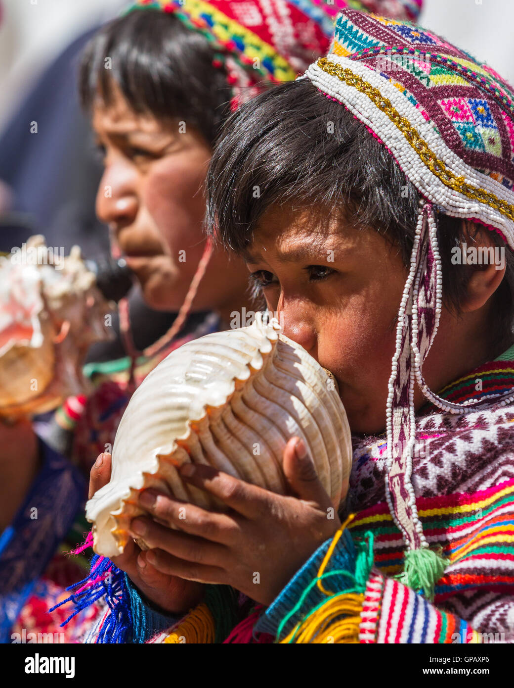 Pisac, Peru - May 15: Young man playing a tune using a conch shell as ...