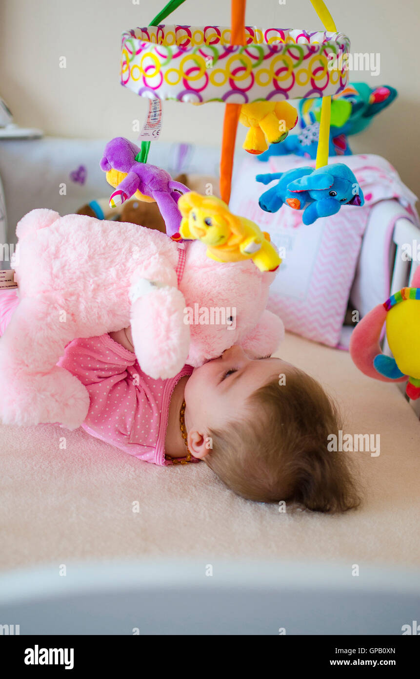 little cute baby girl playing in a cot Stock Photo - Alamy