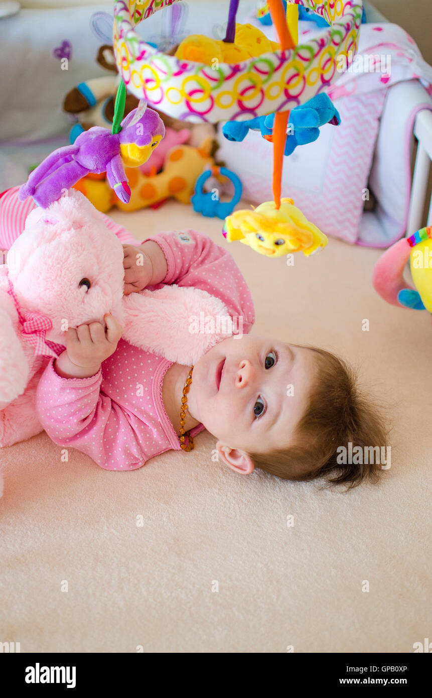 little cute baby girl playing in a cot Stock Photo - Alamy