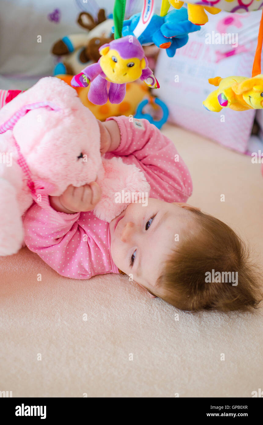 little cute baby girl playing in a cot Stock Photo - Alamy