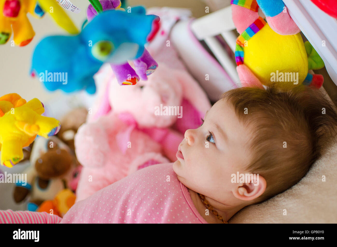 little cute baby girl playing in a cot Stock Photo - Alamy
