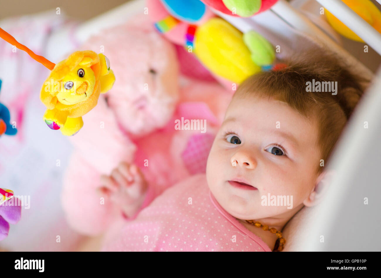 little cute baby girl playing in a cot Stock Photo - Alamy