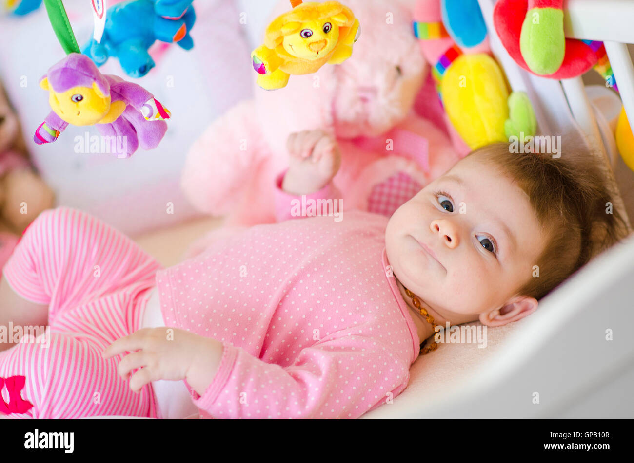 little cute baby girl playing in a cot Stock Photo - Alamy