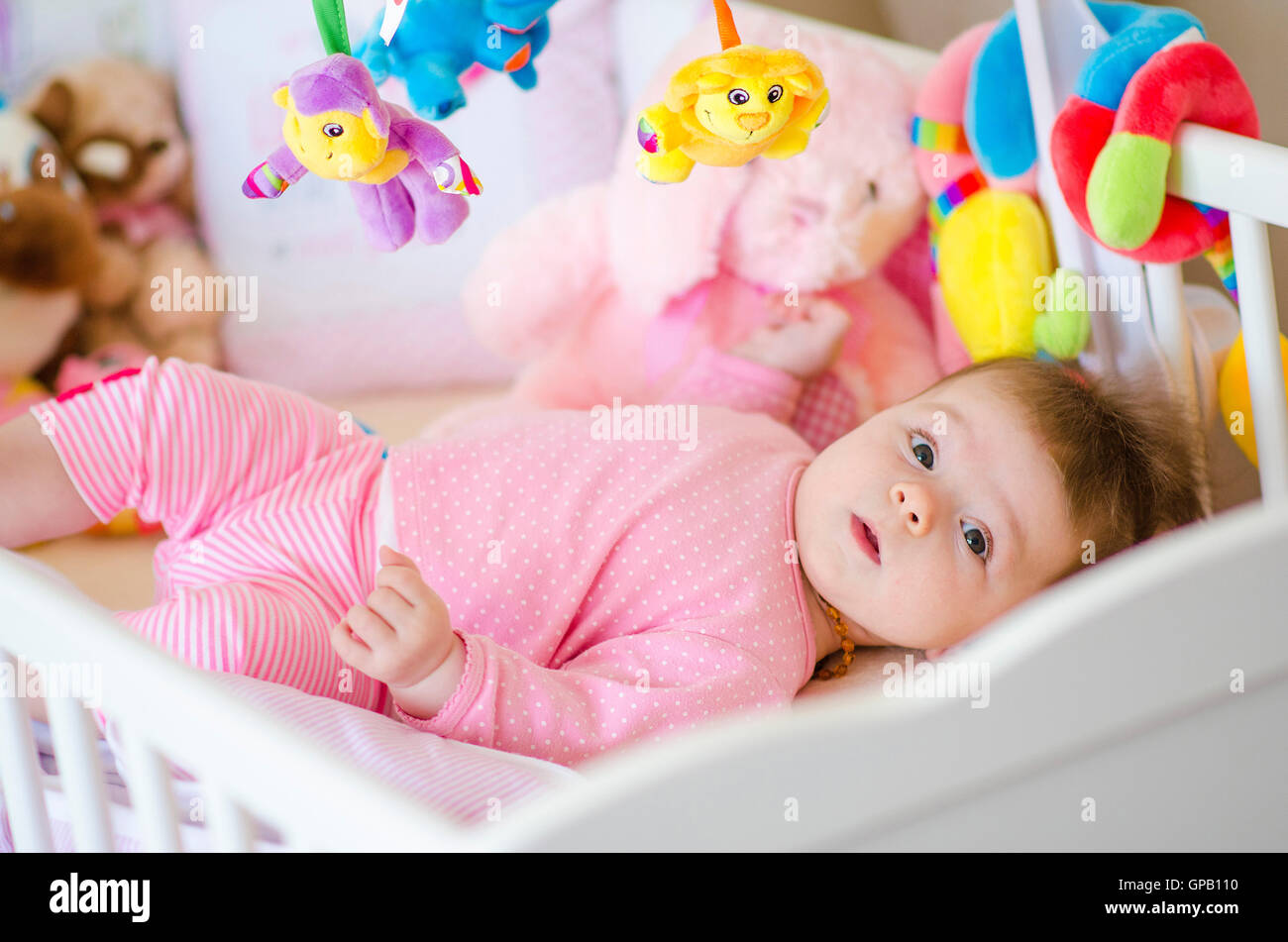 little cute baby girl playing in a cot Stock Photo - Alamy
