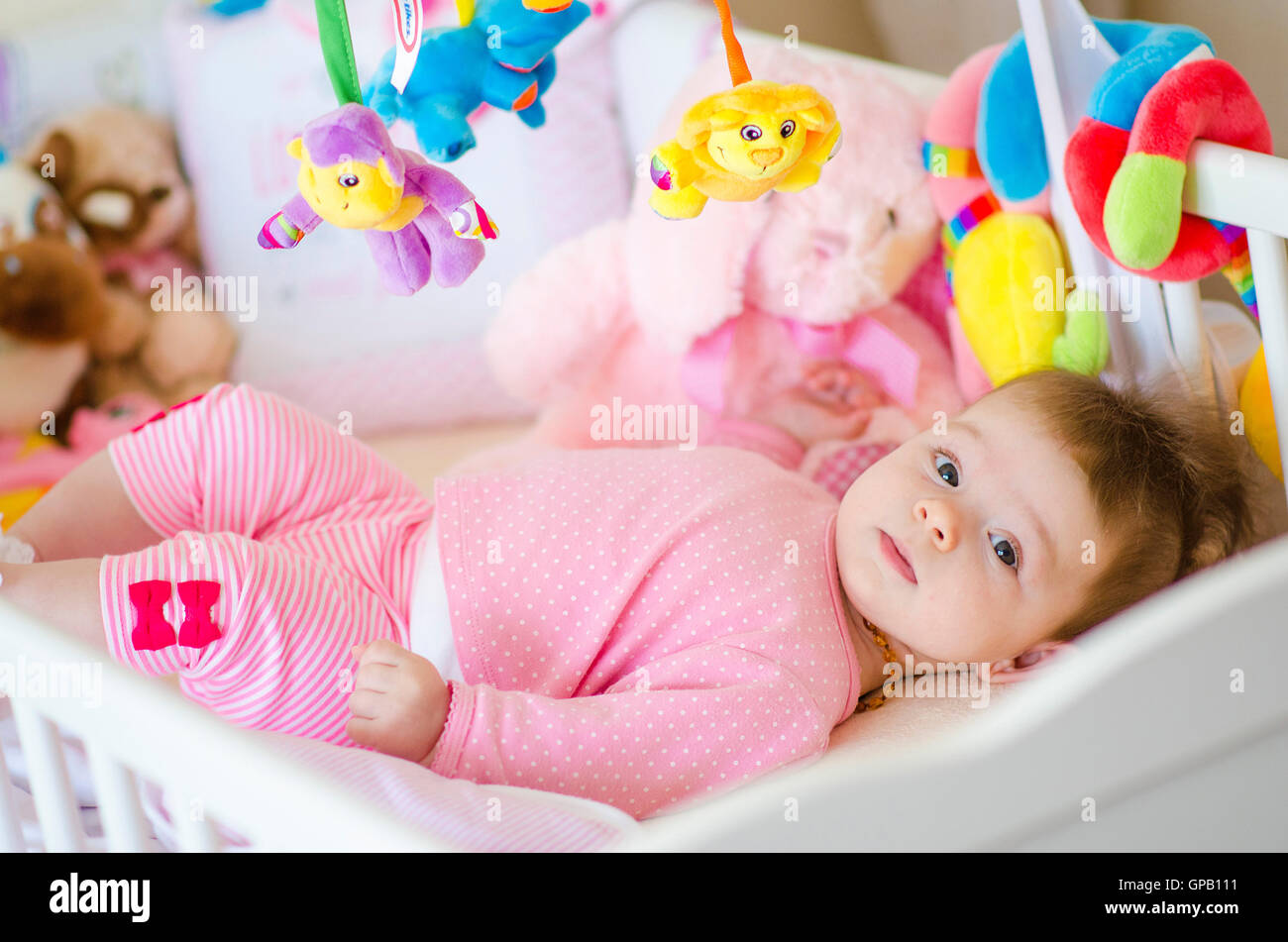 little cute baby girl playing in a cot Stock Photo - Alamy