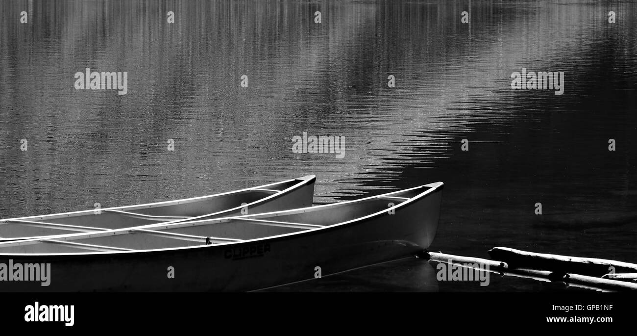 Pair of empty boats sitting at a dock in black and white Stock Photo ...