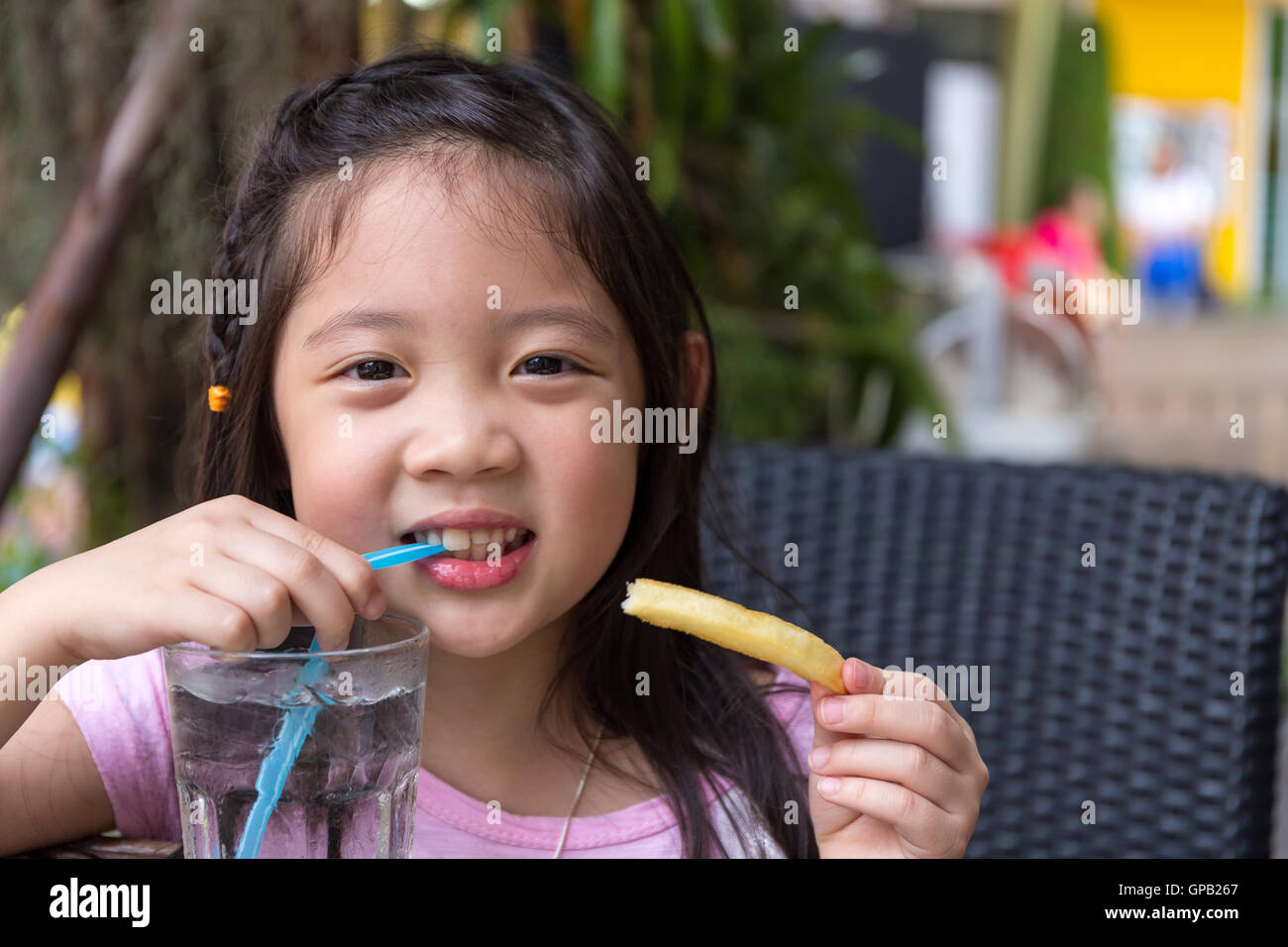Kid eating French fries and water at restaurant Stock Photo - Alamy