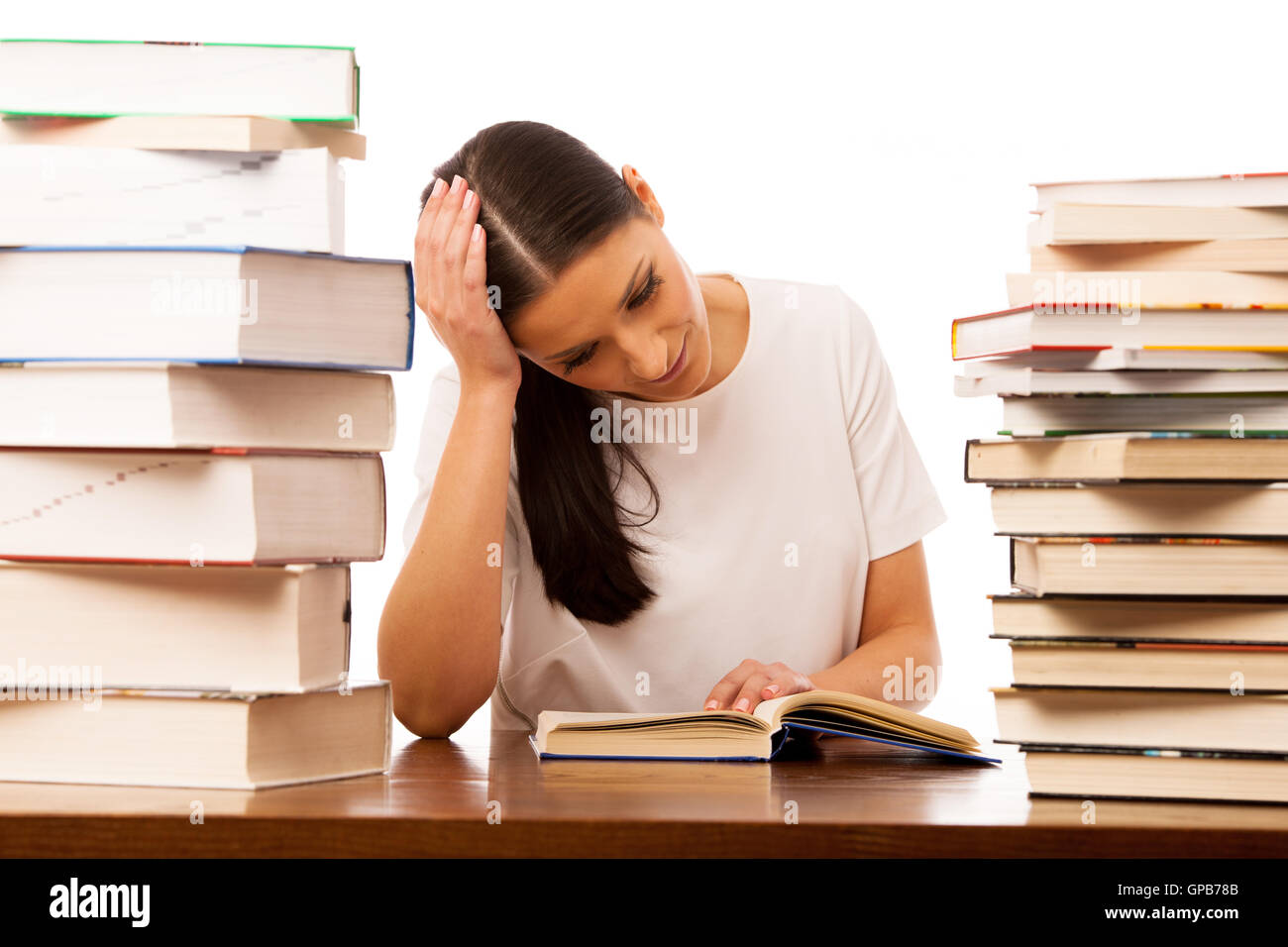 Bored woman reading behind the table between two pile of books Stock ...